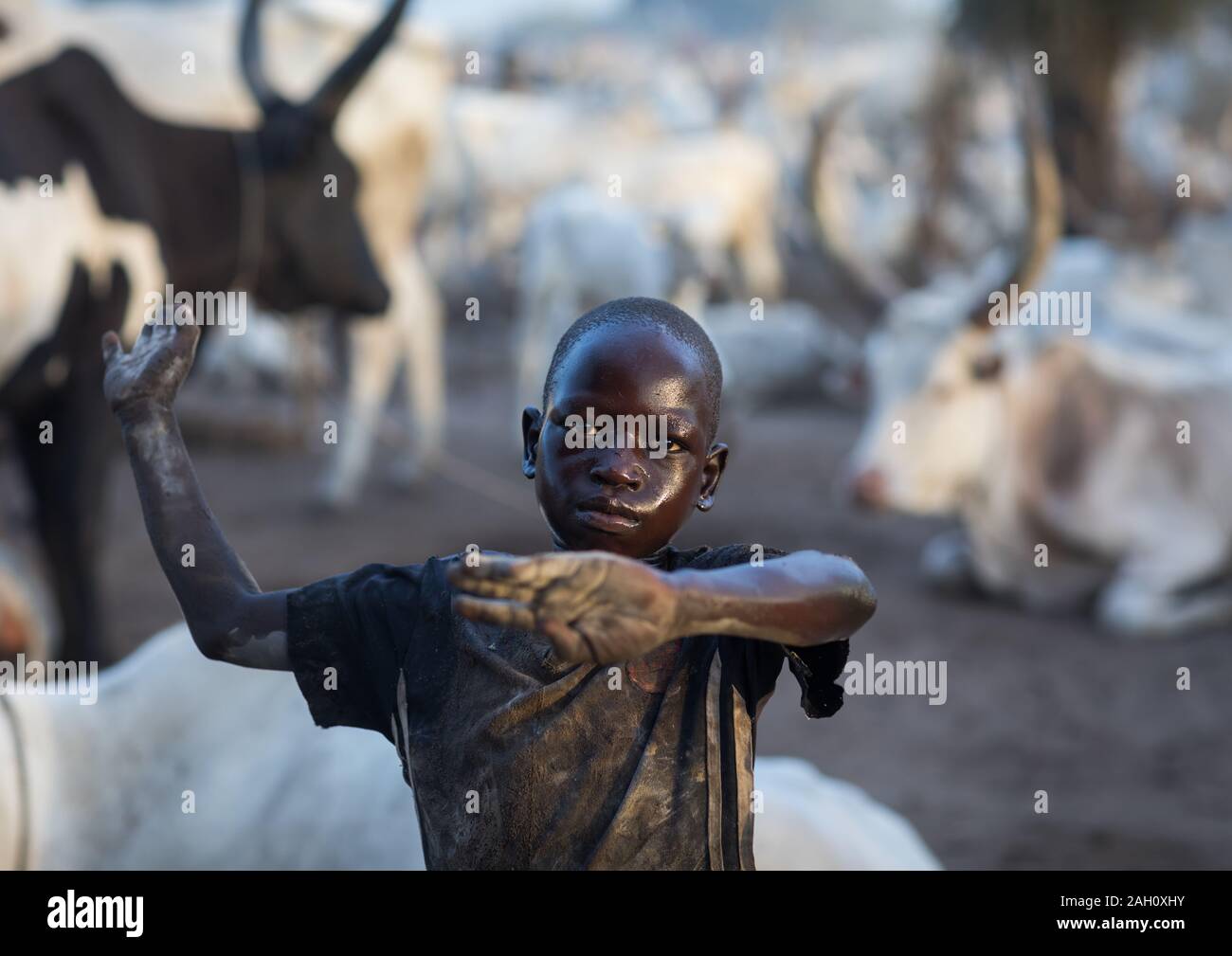 A Mundari tribe boy mimics the position of horns of his favourite cow, Central Equatoria ...