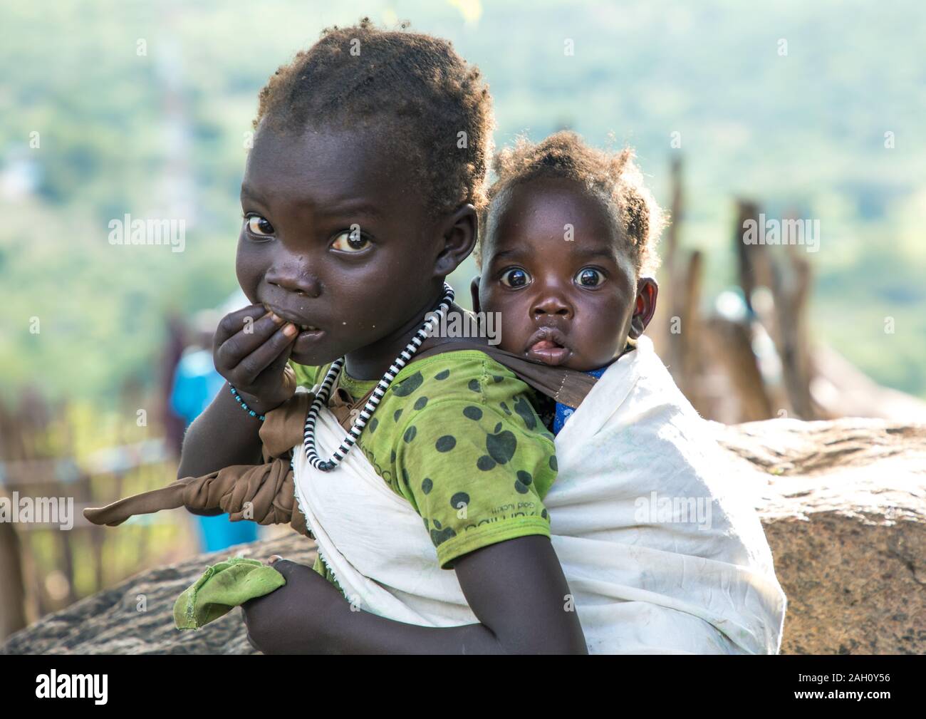Lotuko tribe girl carrying her sister on her back, Central Equatoria ...