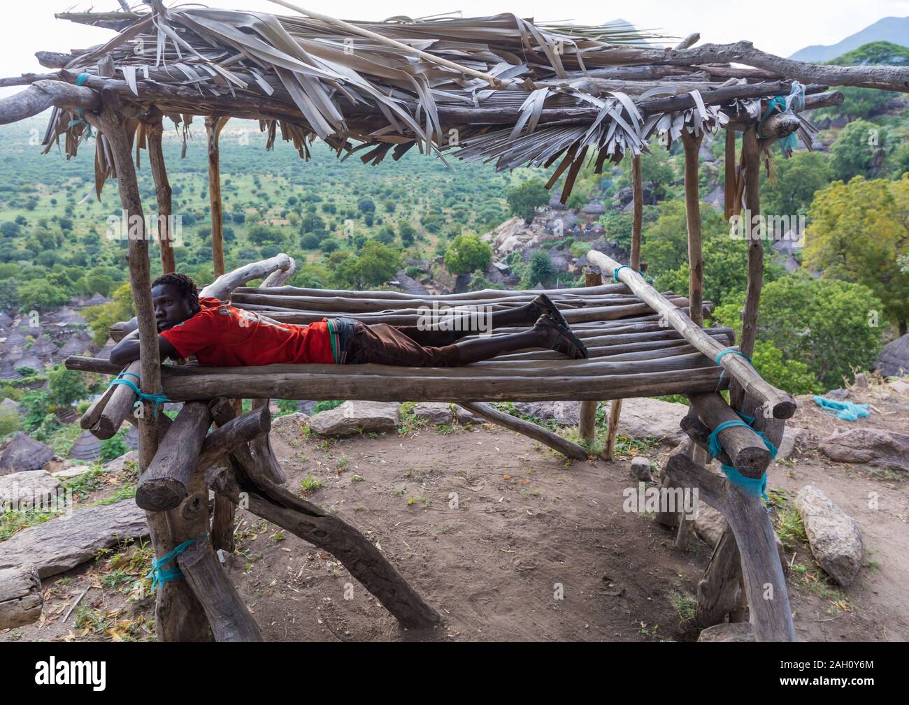 Lotuko tribe man resting on a wood bed, Central Equatoria, Illeu, South ...