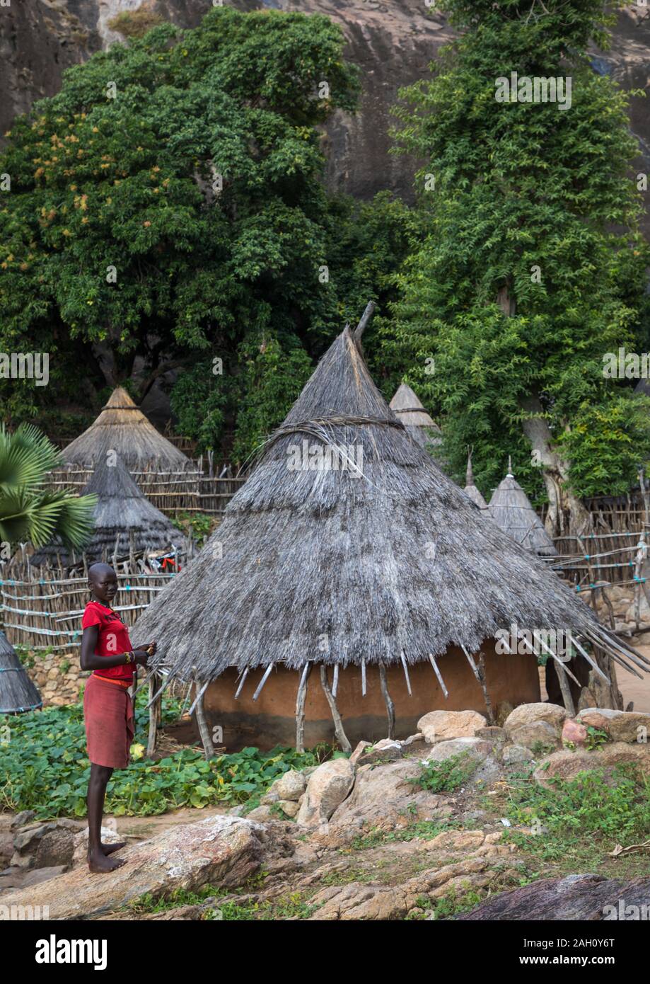 Girl in a Lotuko tribe village with thatched roof houses, Central ...