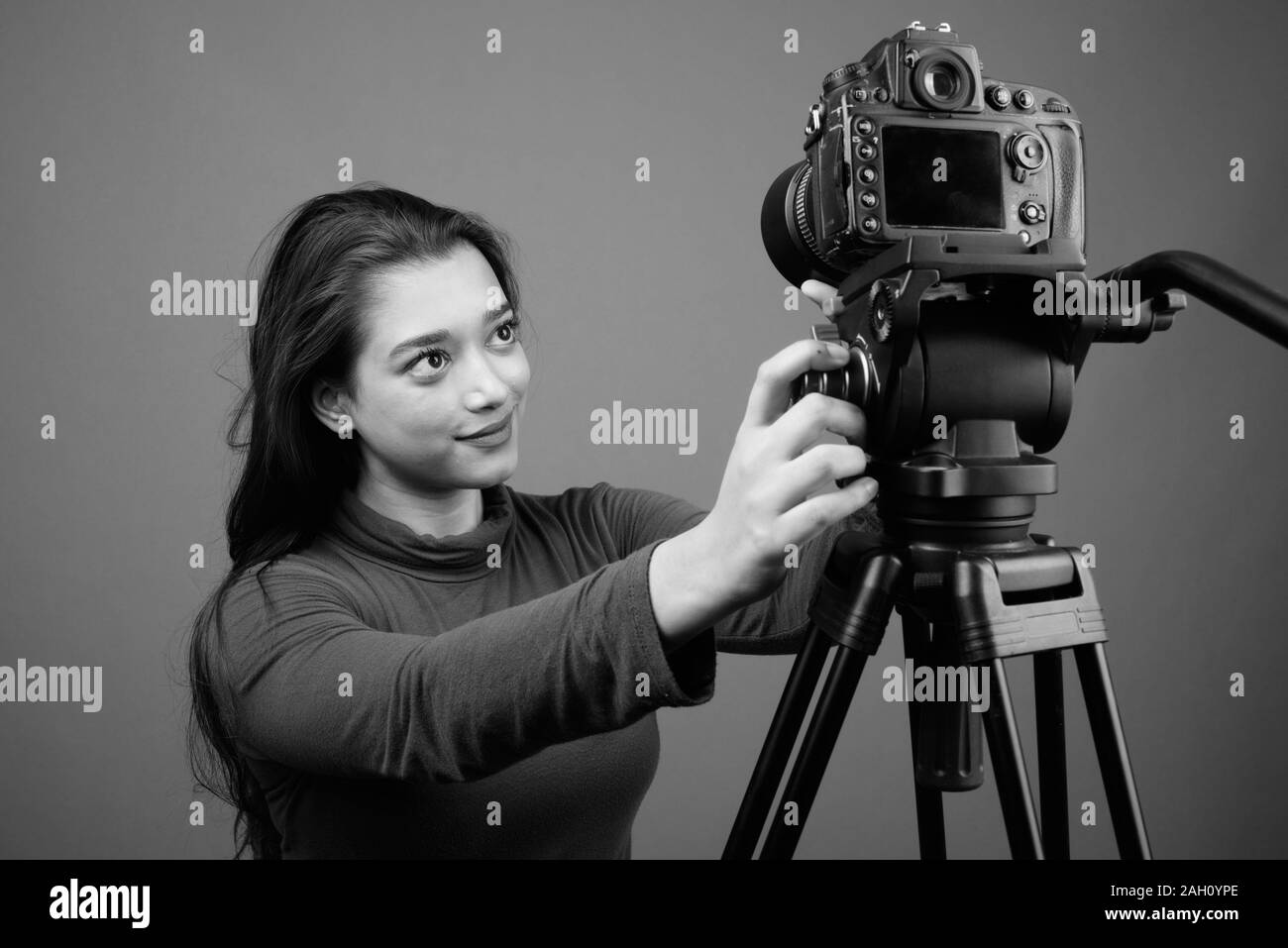 Young beautiful Indian woman vlogging against gray background Stock ...