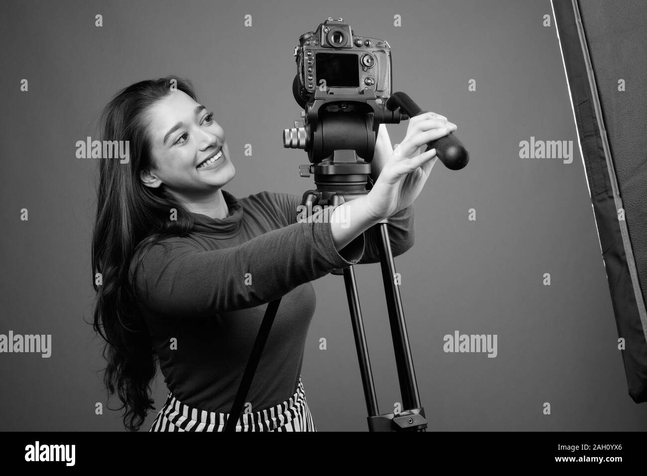 Young beautiful Indian woman vlogging against gray background Stock ...