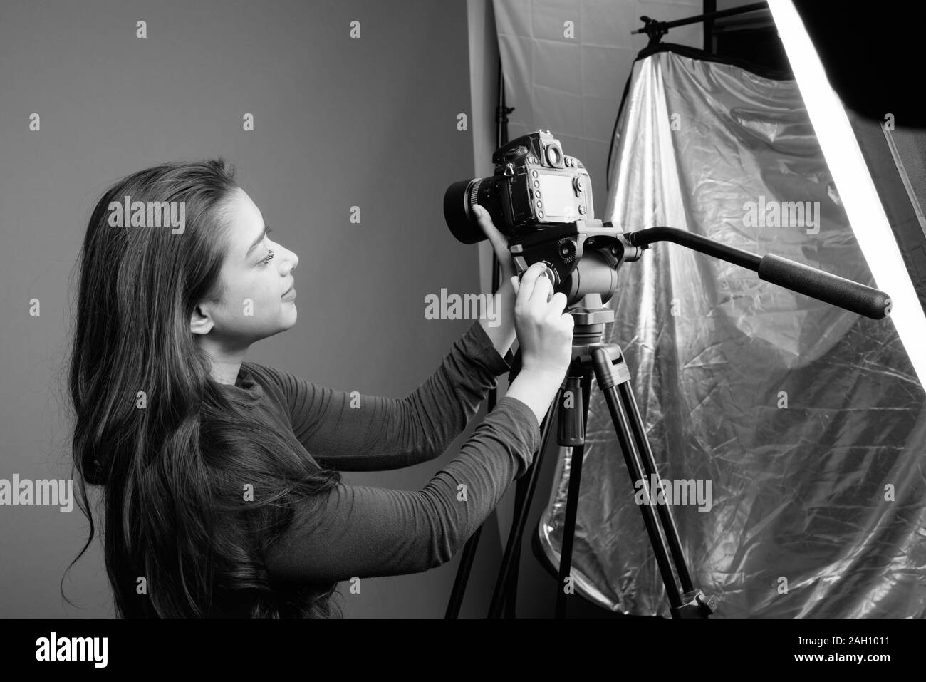 Young beautiful Indian woman vlogging against gray background Stock ...