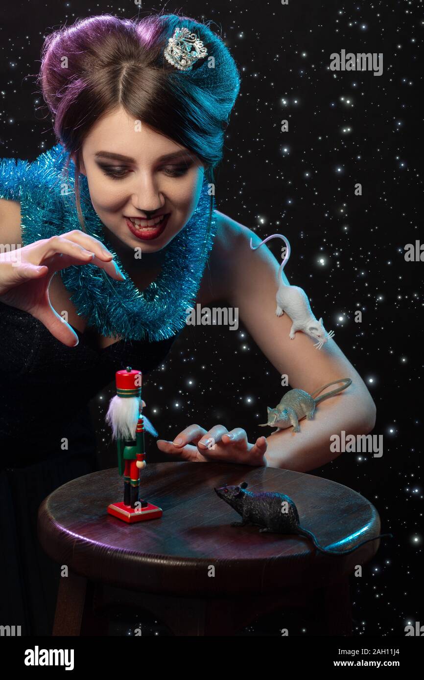 girl in Mouse Queen costume plays with Nutcracker toy on black ...