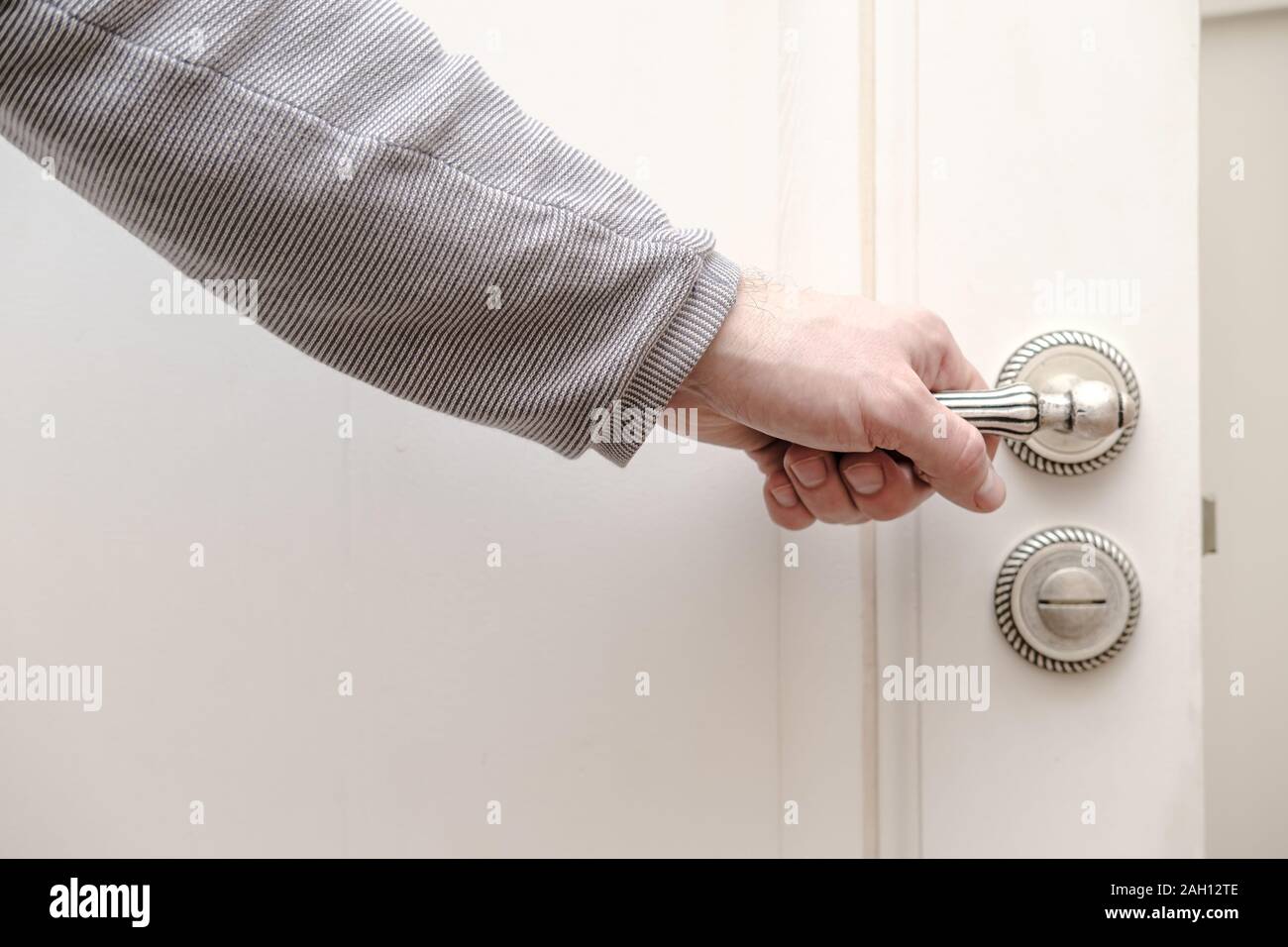 Human hand holding on to a beautiful carved, metal handle in an open ...