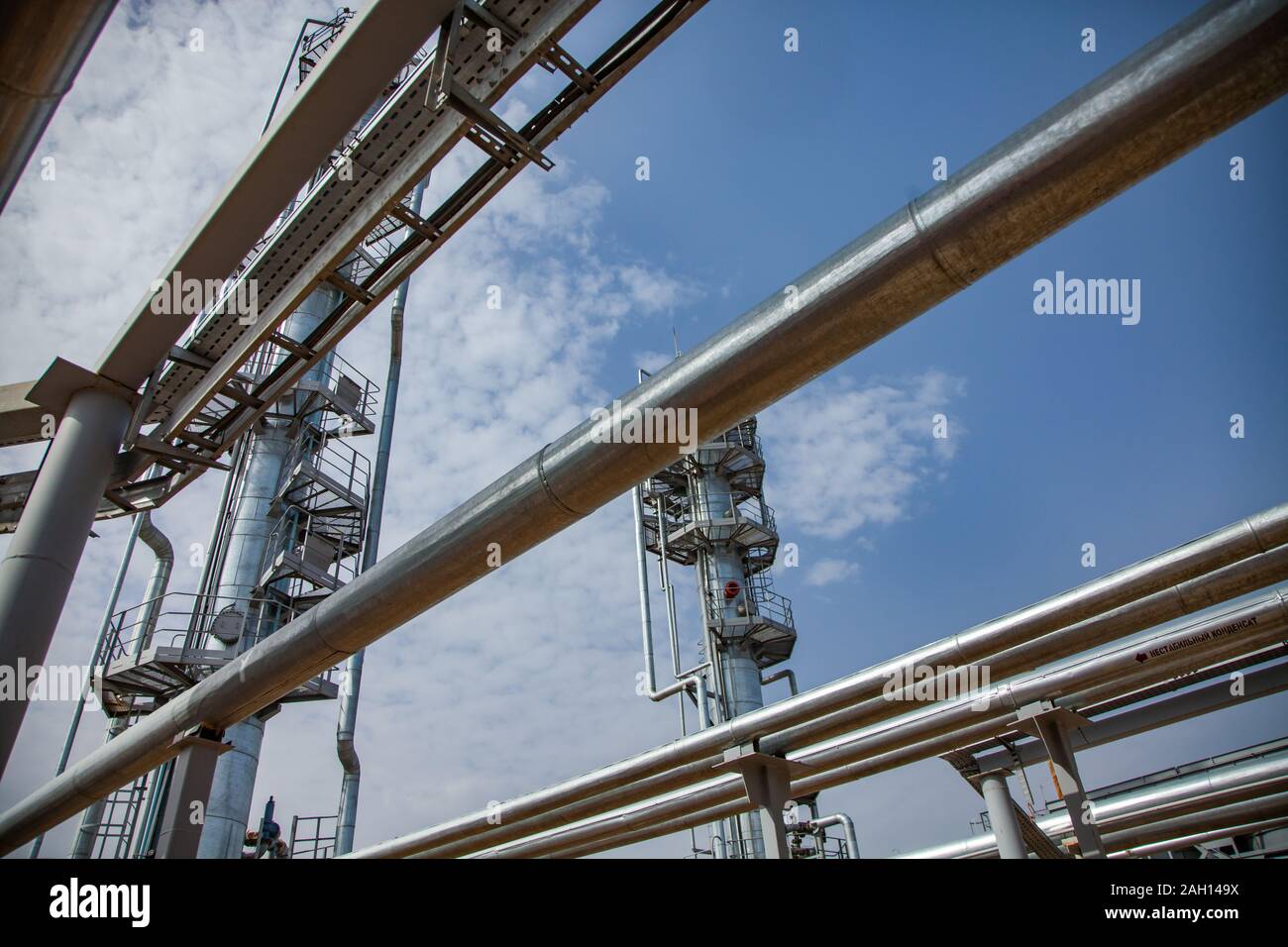 Grey metal pipes and refinery columns on oil refinery plant on blue sky ...