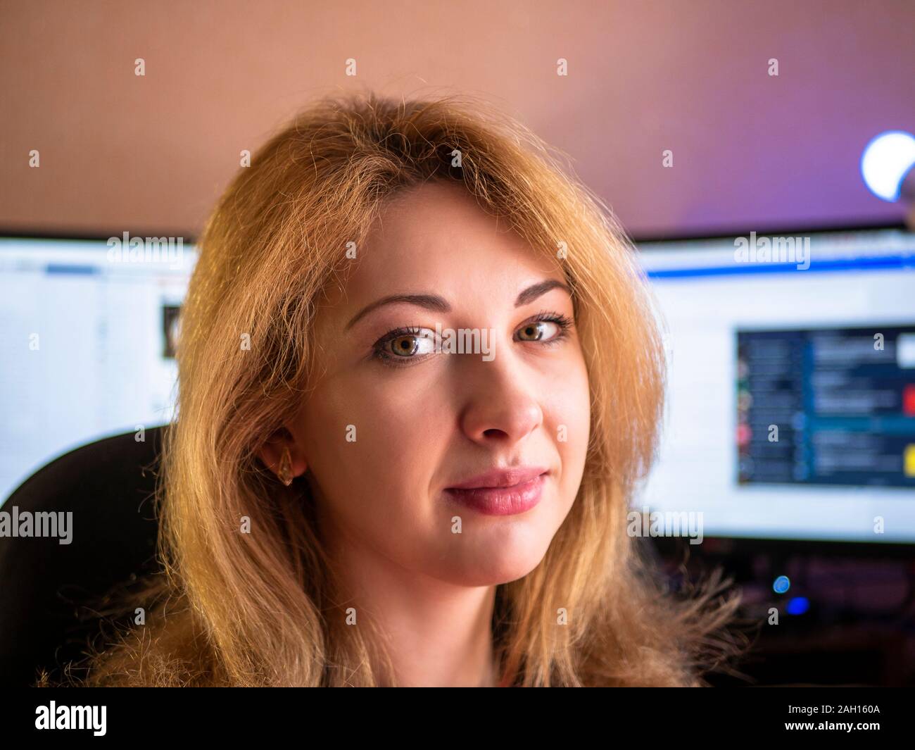 Portrait of smiling female office manager sitting at office desk with ...