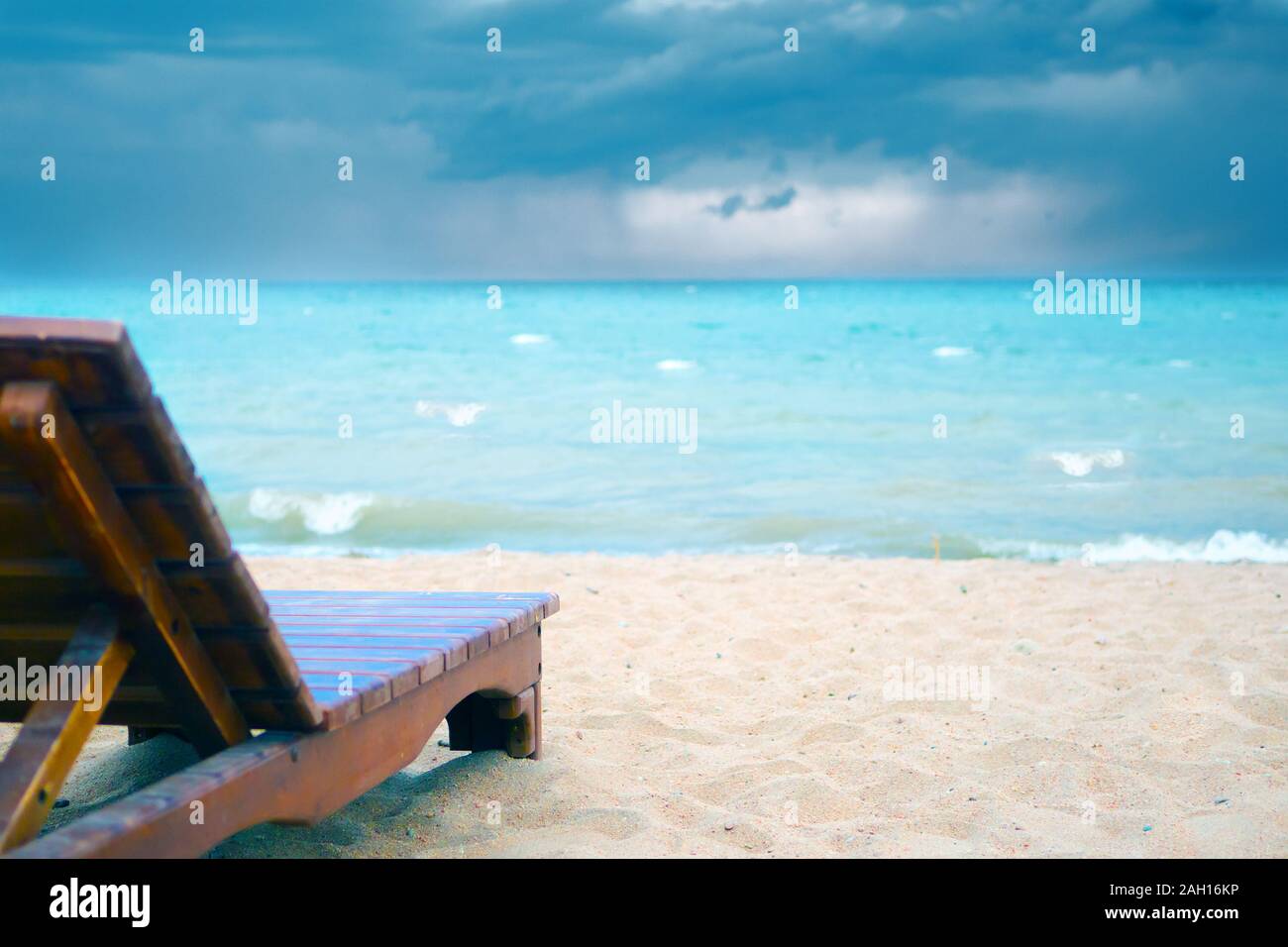 Bad weather on the beach without people. Sunbed on the beach. Spoiled ...