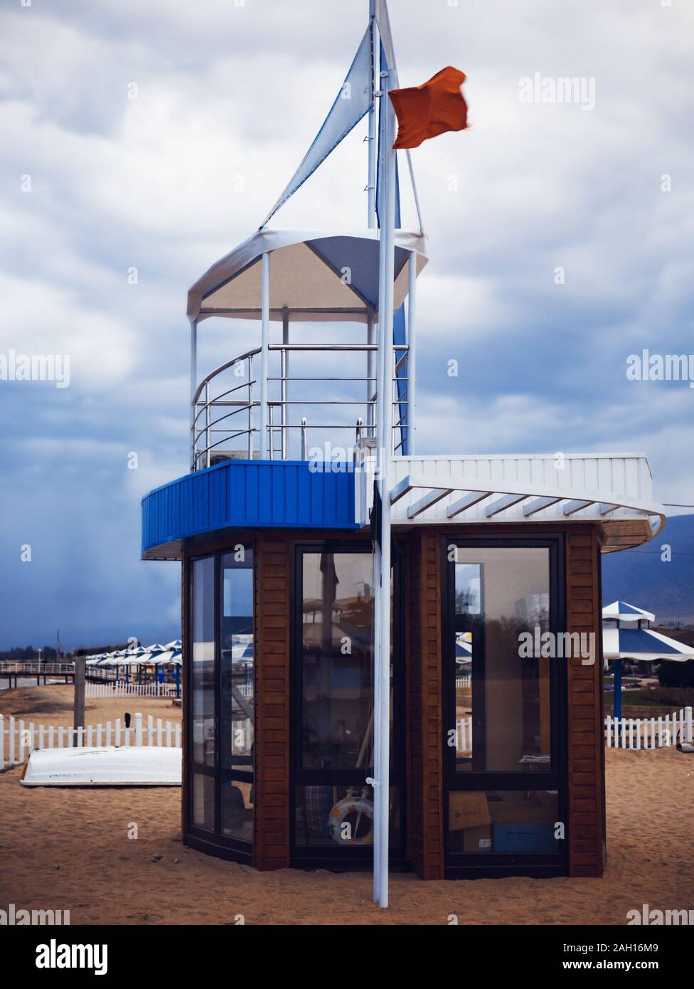 Life-saving tower in the ocean on the beach with red flag and bad ...