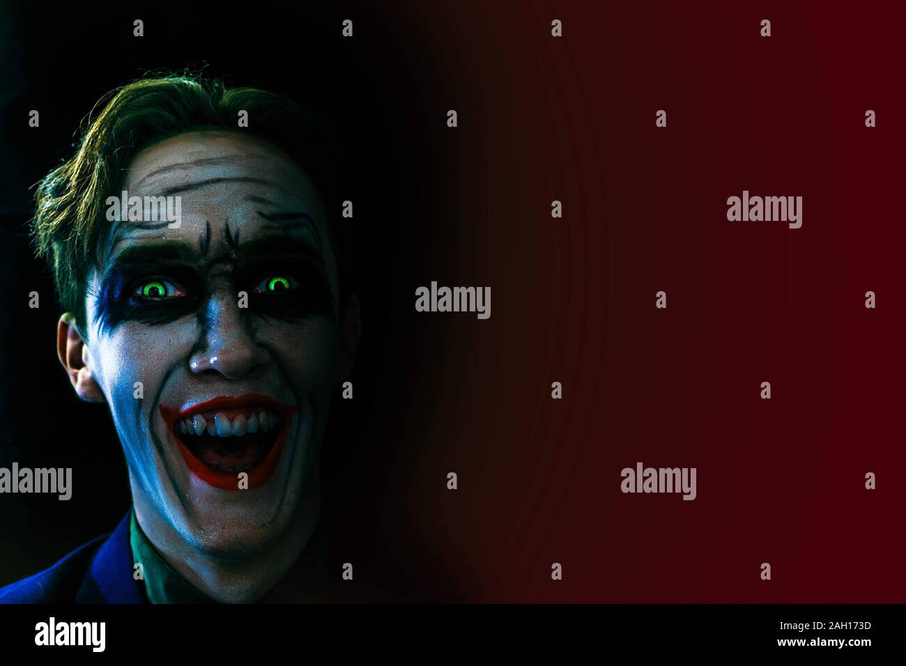 A dark, creepy joker screaming laughter in the dark. Halloween party ...