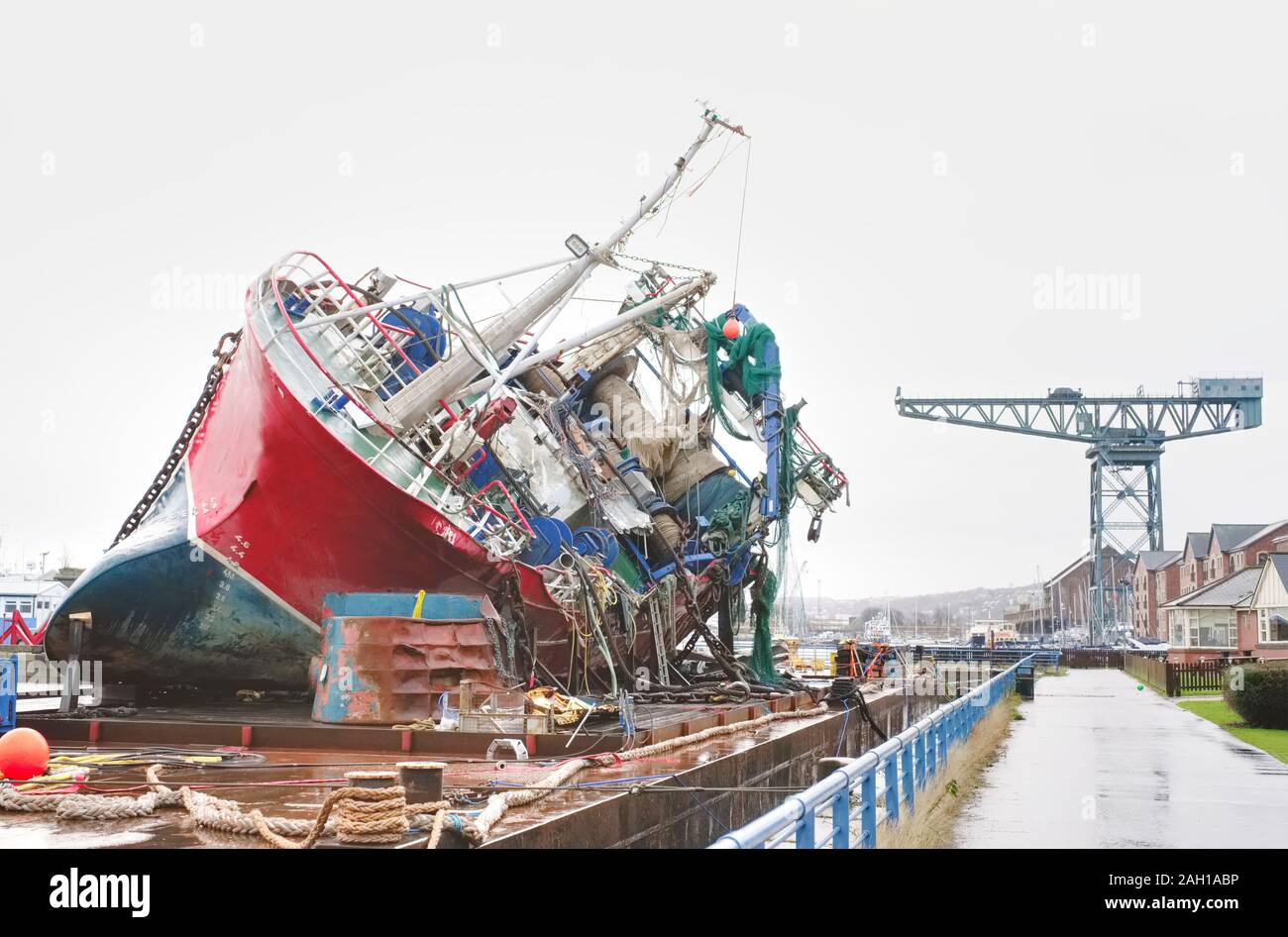 Capsized ship vessel and rescue lift crane at port dock for repair of ...