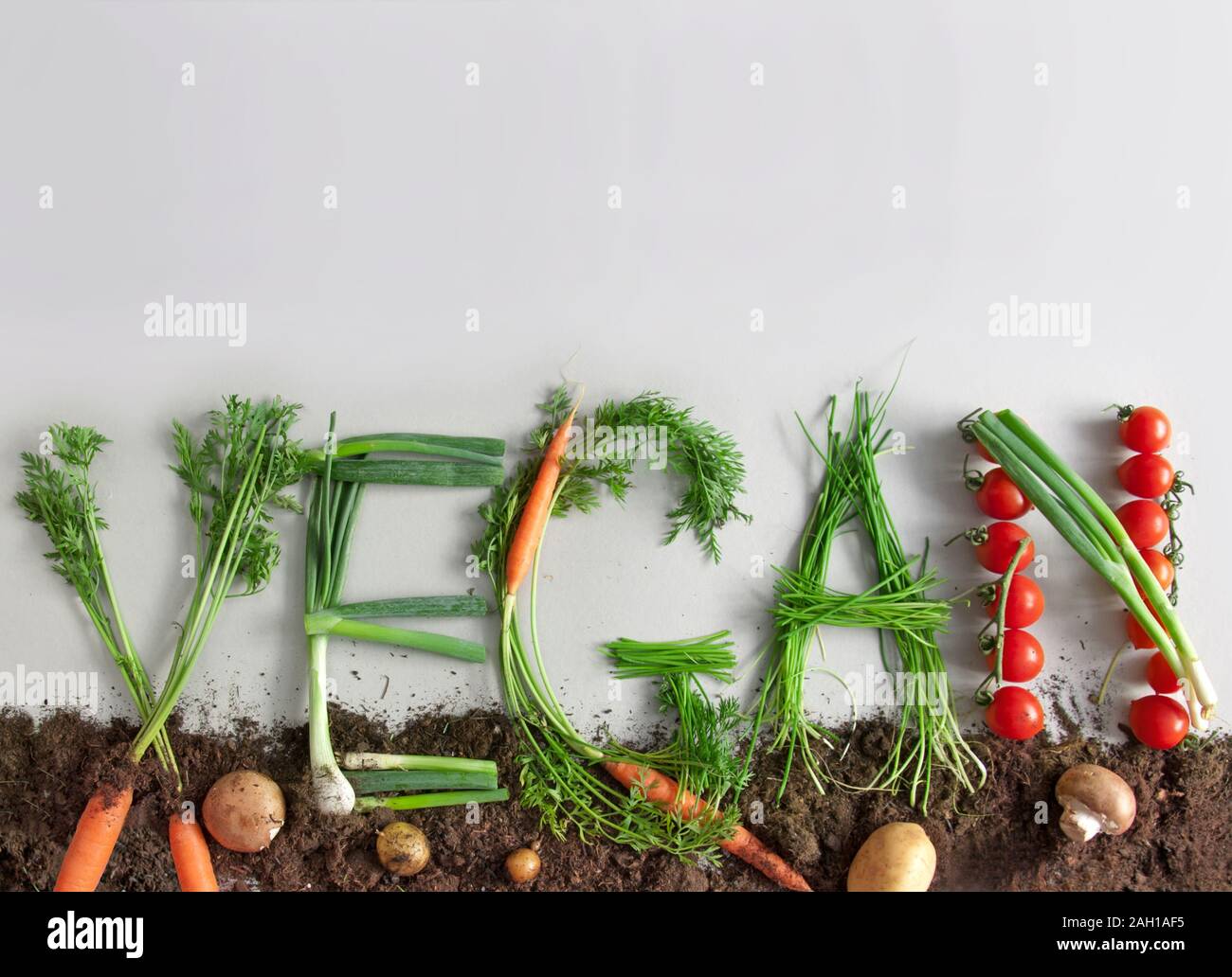 Vegan letters made from organic fruits and vegetables growing in a ...
