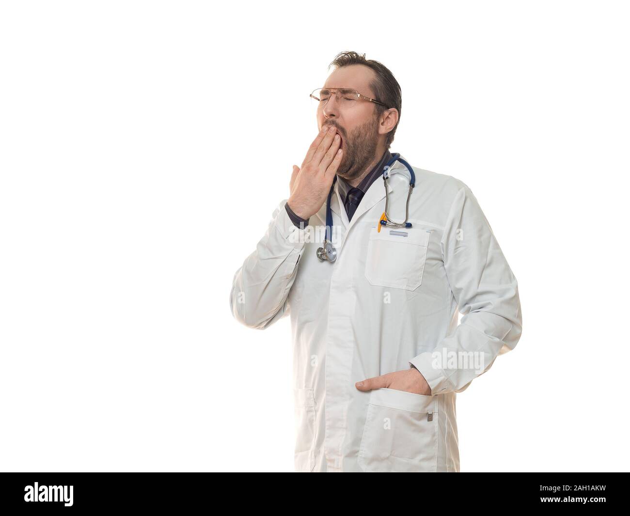 Male doctor wearing stethoscope over white background bored yawning ...