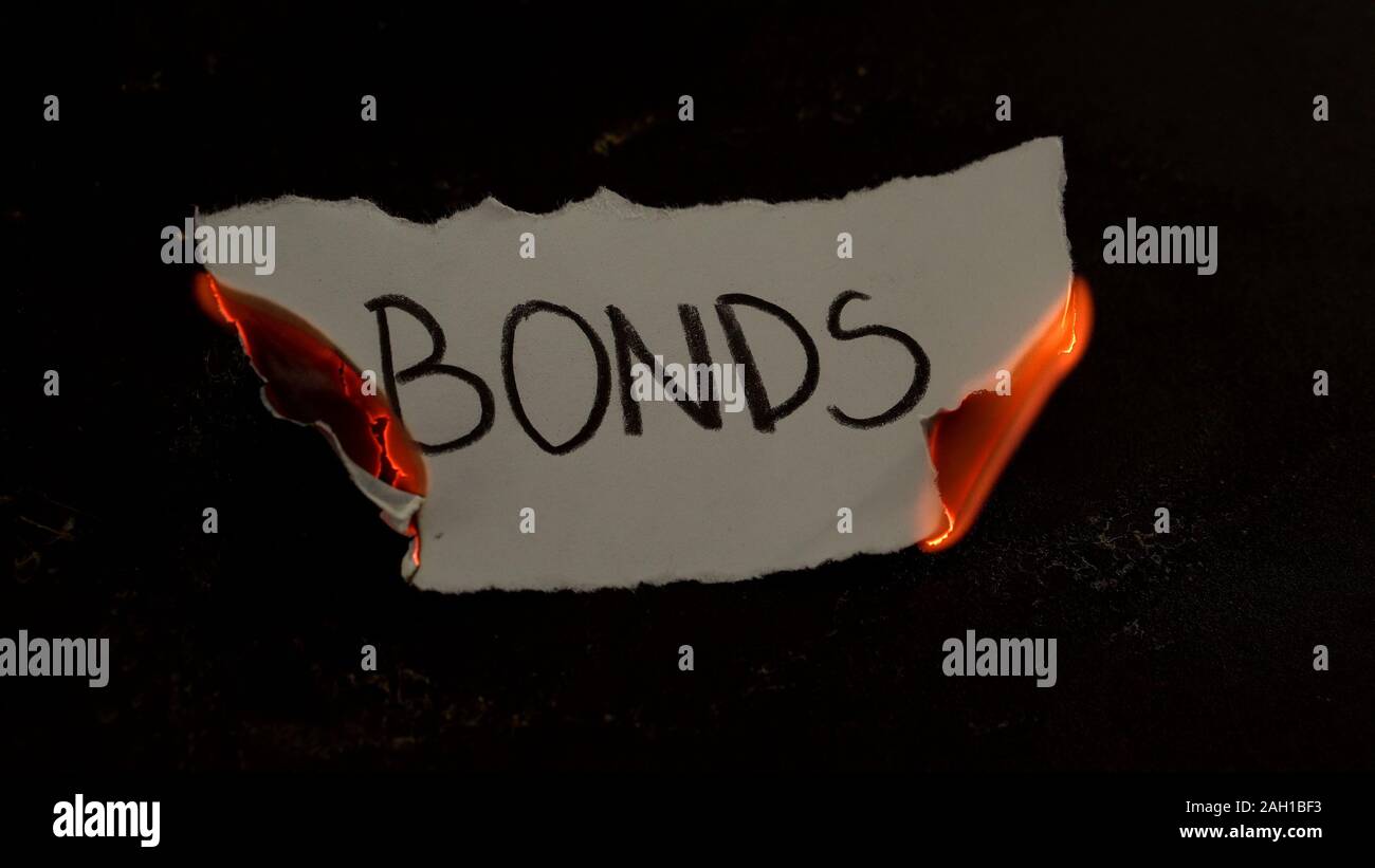 Bonds word written on white paper burns. Fire with smoke and ashes on ...