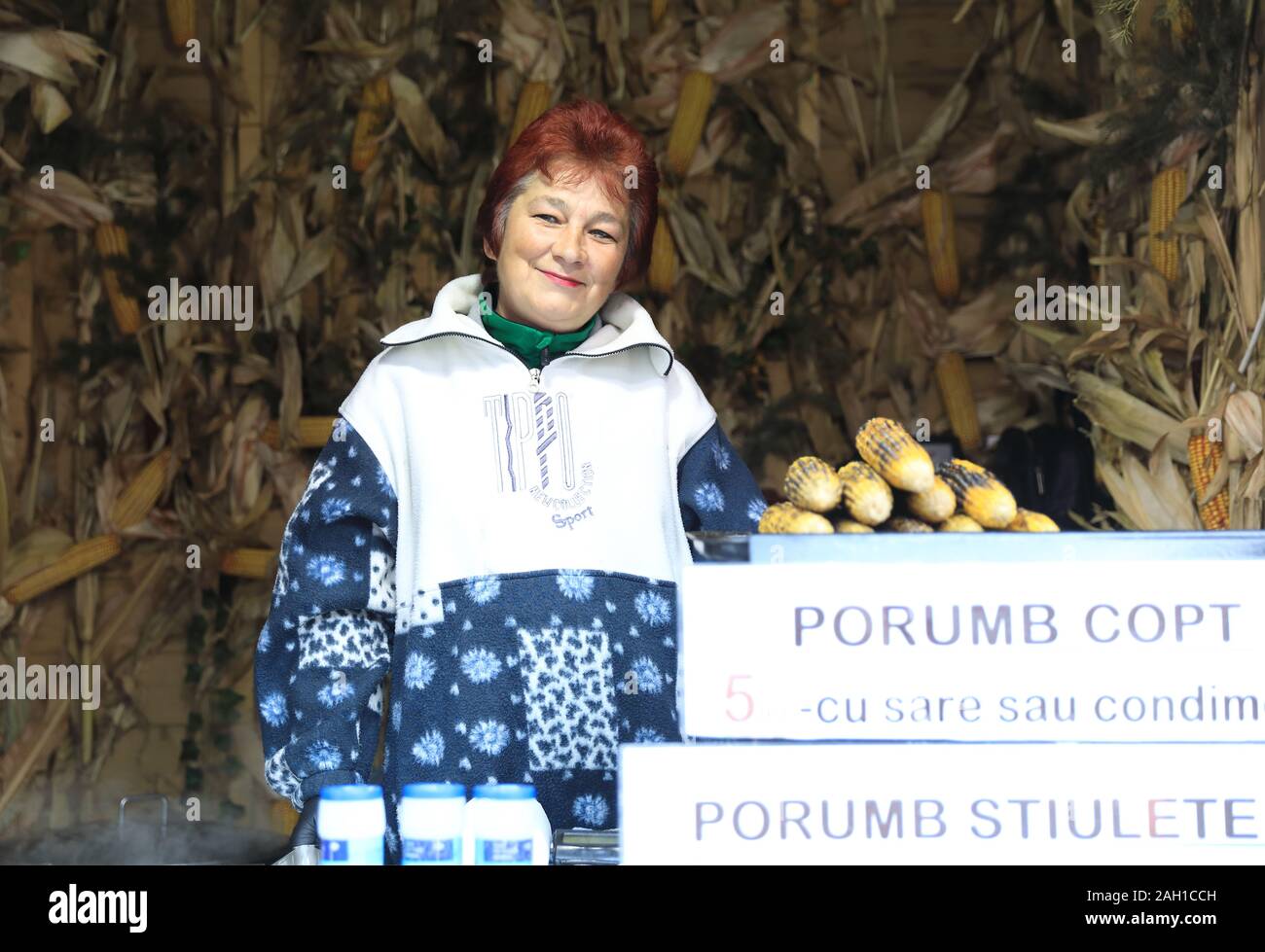 Lady selling traditional corn on the cob on a stall on the Christmas ...