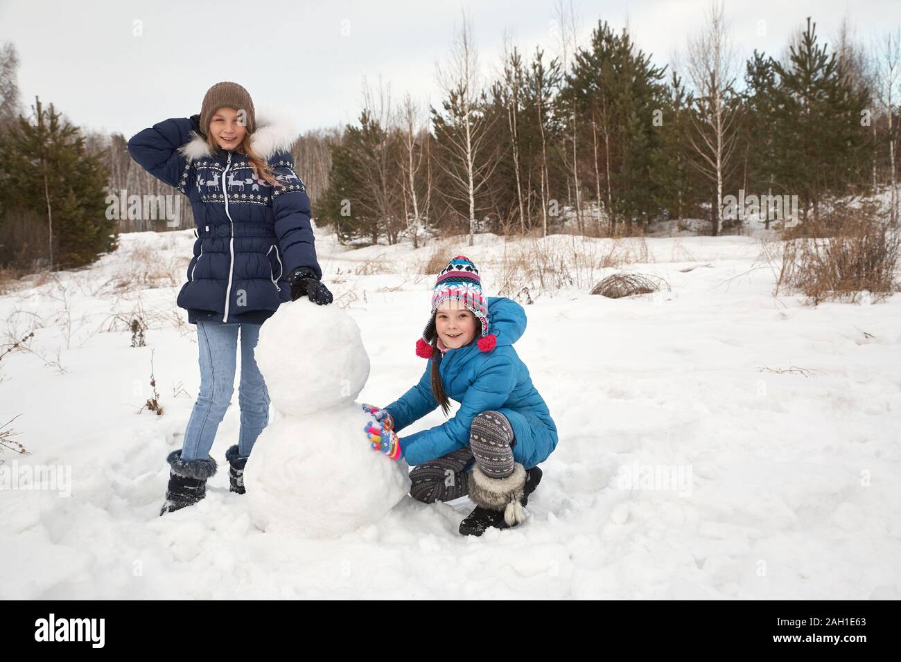Children building a snowman hi-res stock photography and images - Alamy