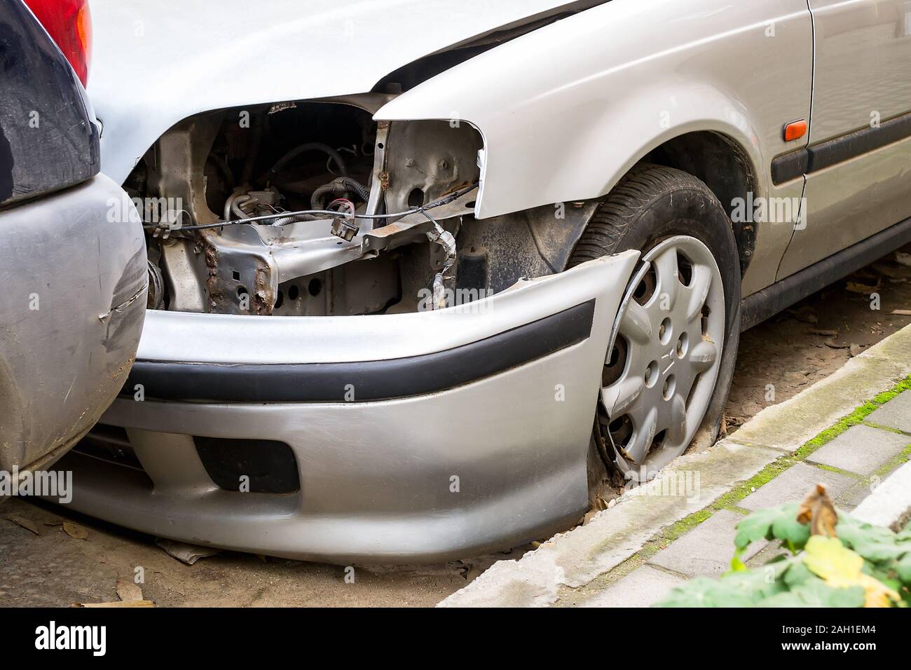 Stationary silver colored car without a headlight and with a fallen off ...