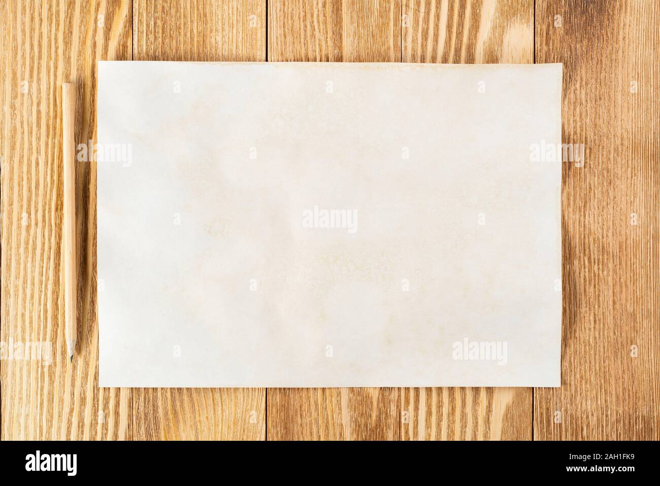 Sheet of paper lying on wooden table. Rectangular blank white old paper ...