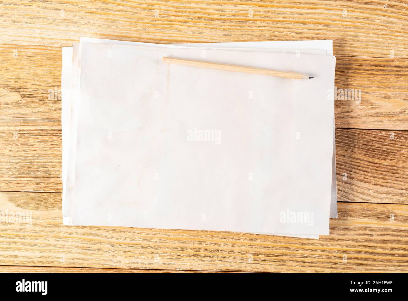 Sheet of paper lying on wooden table. Rectangular blank white old paper ...