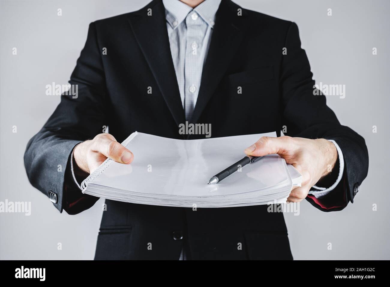 Person giving out book of papers or a large case for signature or deal ...