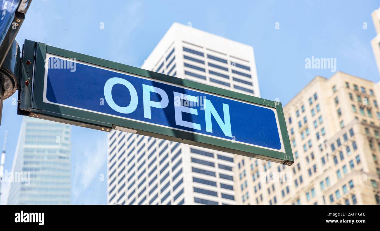 Open street sign, blue color road sign, text open. Highrise buildings ...