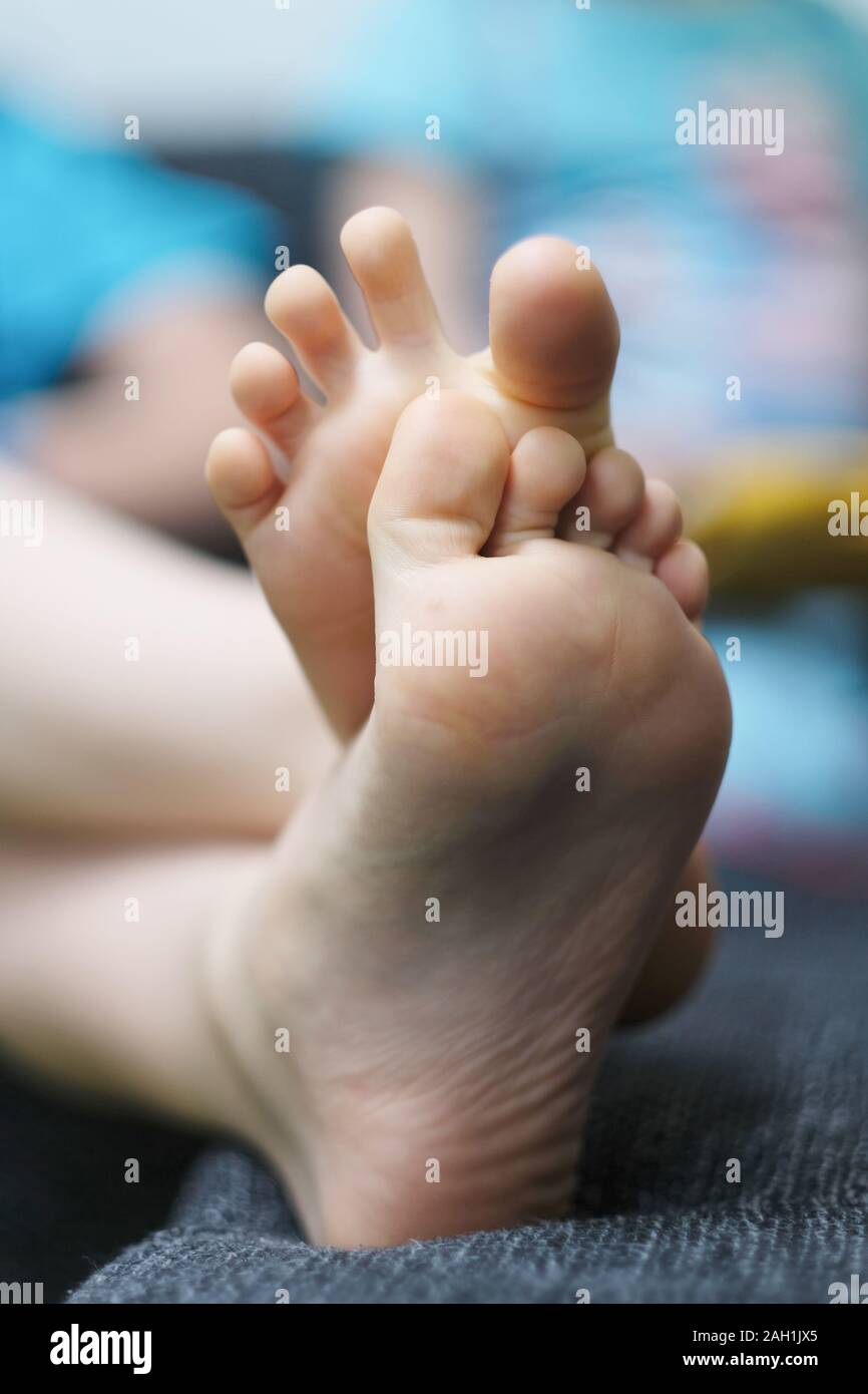 The outstretched and crossed legs of a child of school age lie on the ...