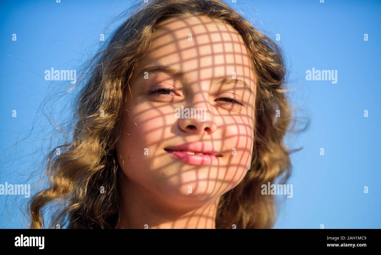 Sunscreen concept. Child pleased with warm sunlight looks relaxed blue ...