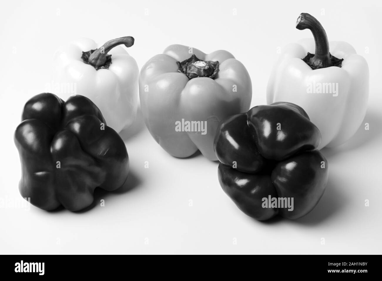 Four peppers of different shades of gray Stock Photo - Alamy