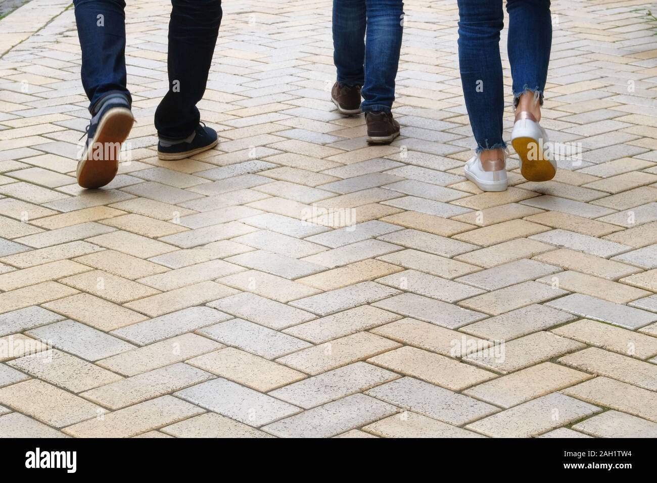 People walk along footpath. Yellow Paving slab. Pedestrian zone in the ...
