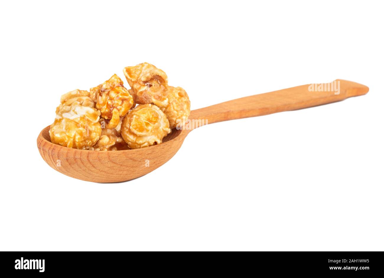 Caramel popcorn in wooden spoon isolated on white background Stock ...