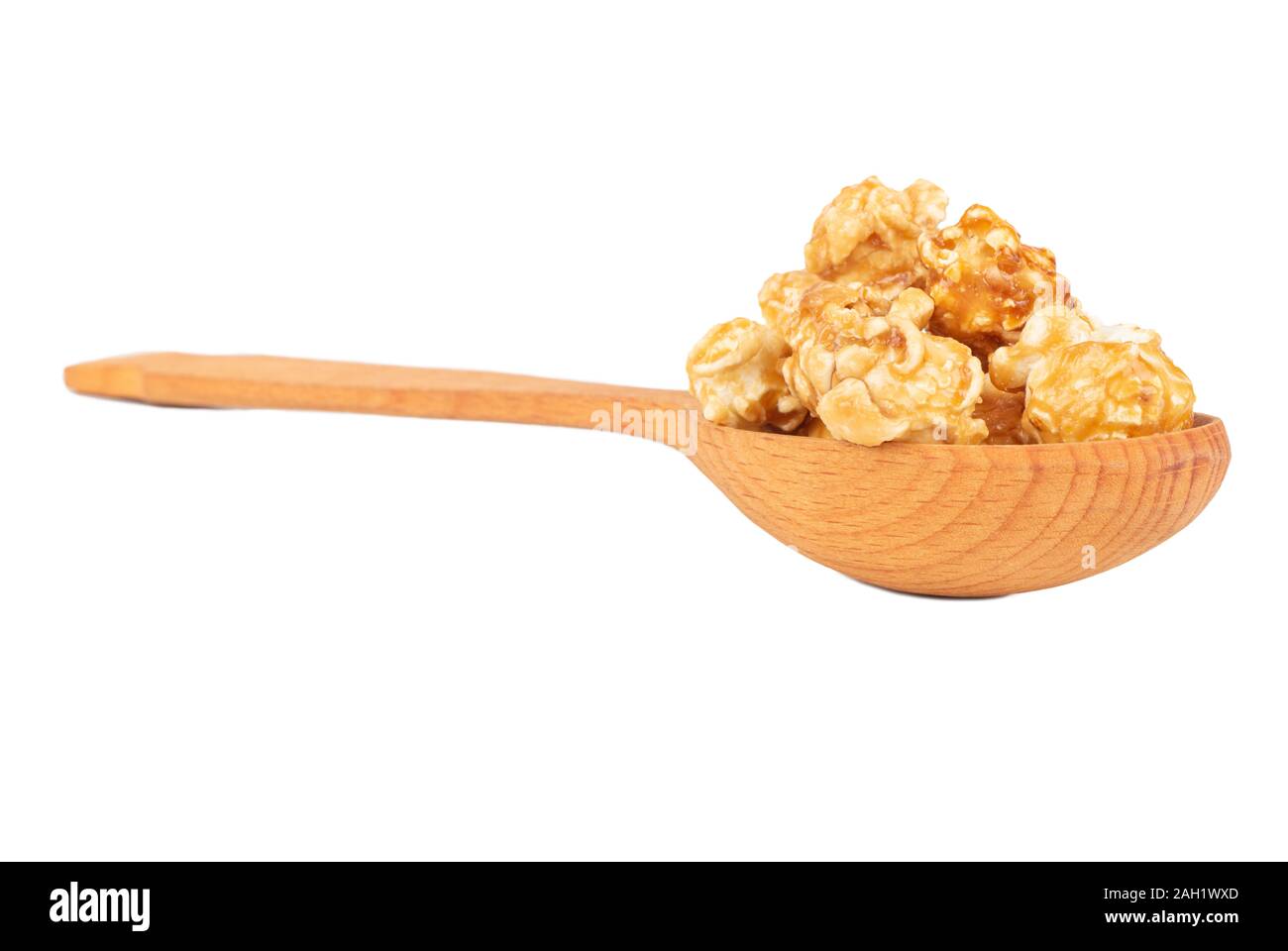 Caramel popcorn in wooden spoon close up on white background Stock ...