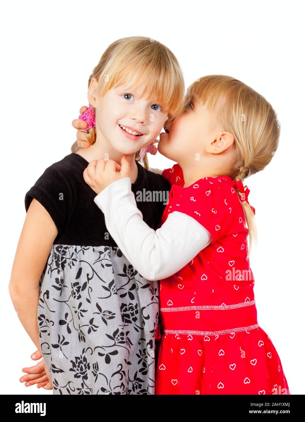 Portrait of little girl telling a secret to her friend over a white ...