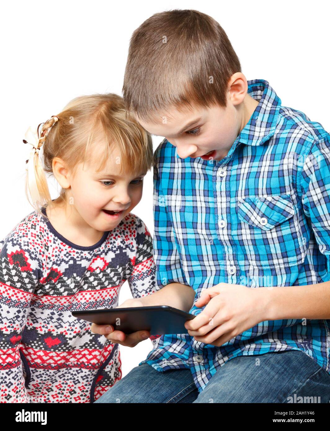 Boy playing on a touch pad with little sister Stock Photo - Alamy