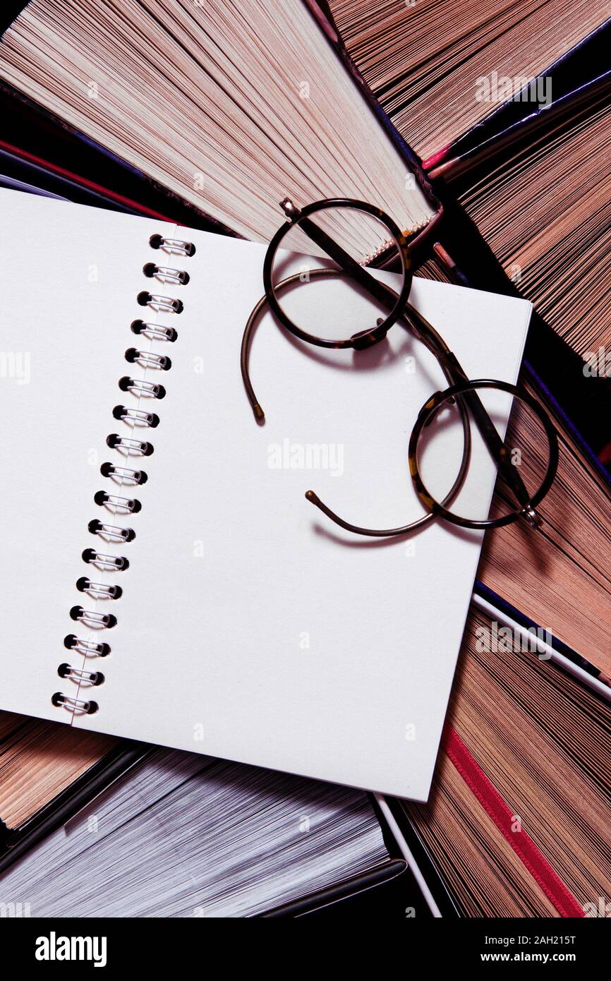 Many multicolored open old books stand on the bookshelf against a dark ...