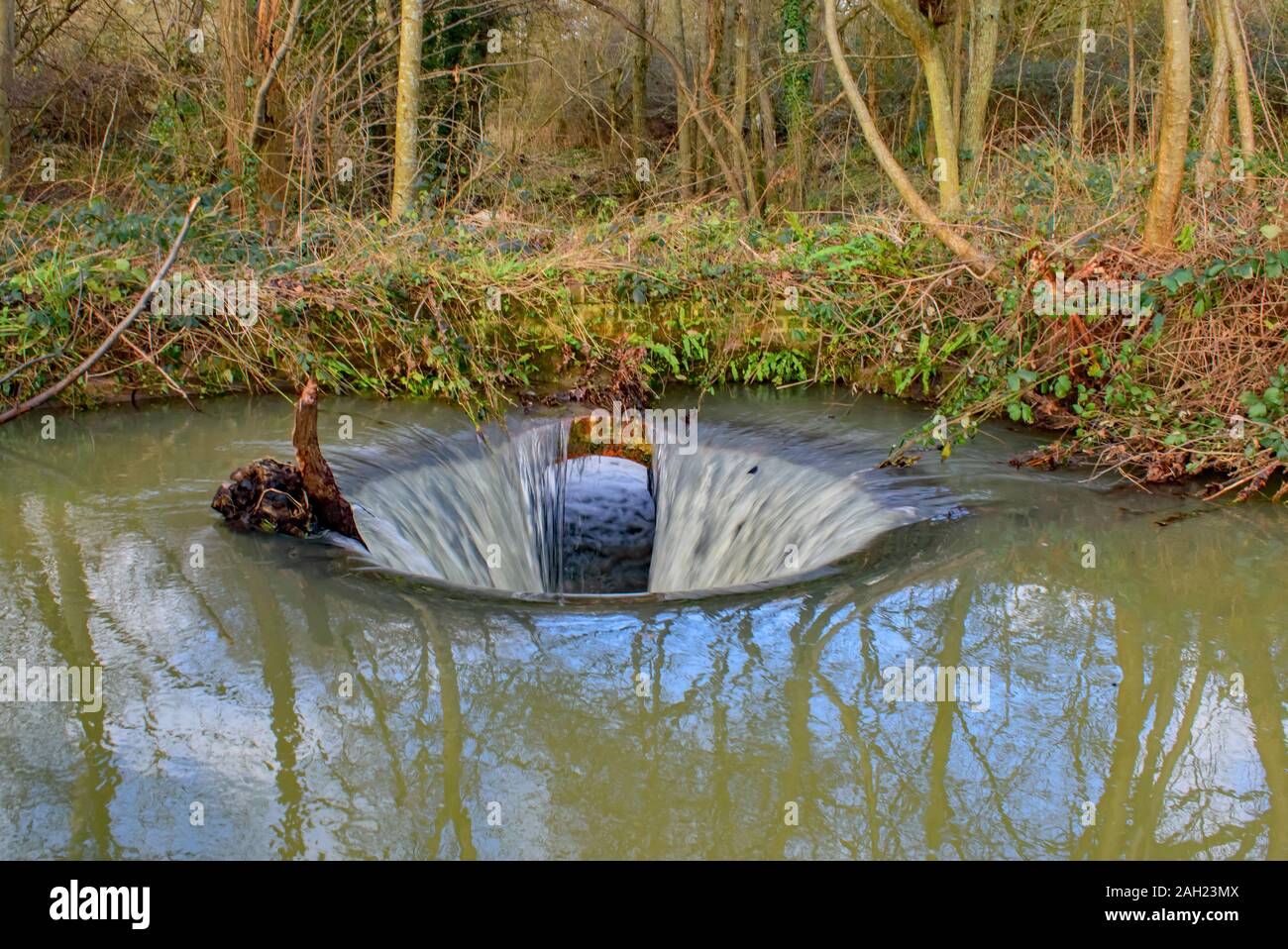 Water falls down a brick plughole in the hidden woodland stream Stock ...