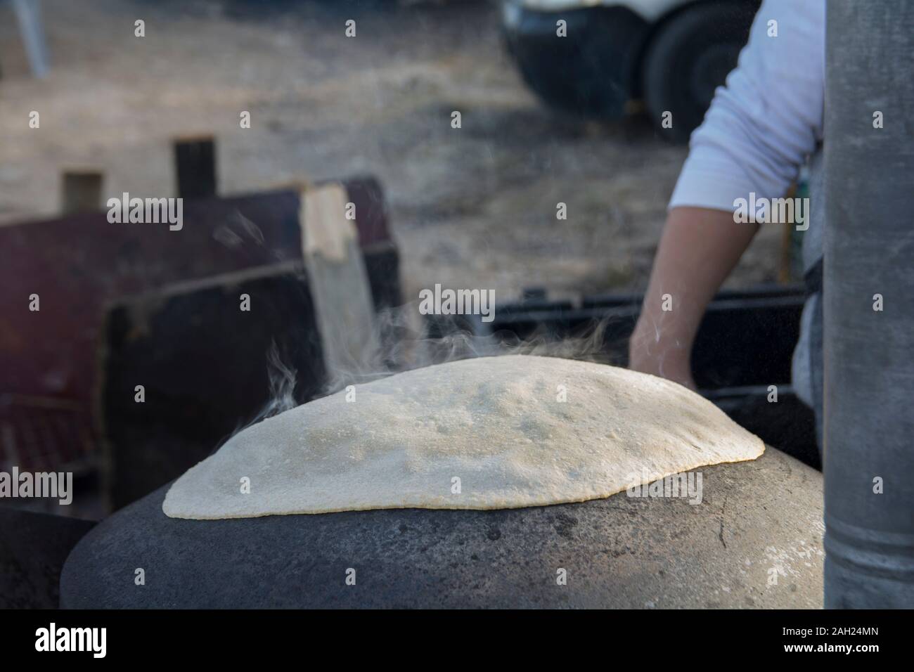 Man baking a traditional Druze Pita bread, on a Saj or Tava Stock Photo ...