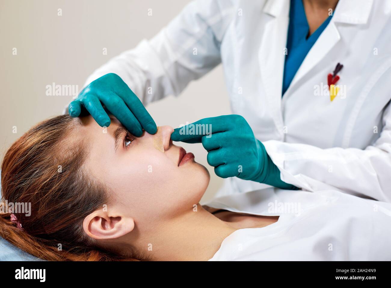 Lady with plaster on nose, doctor examining patients face after plastic ...