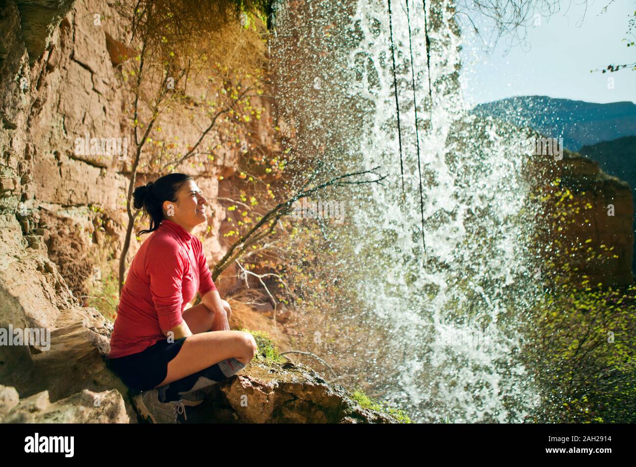 Smiling young woman taking a break from hiking Stock Photo - Alamy