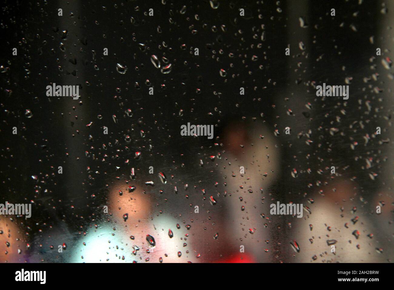 Rain on car's window. Driving at night in the rain. Silhouettes seen ...