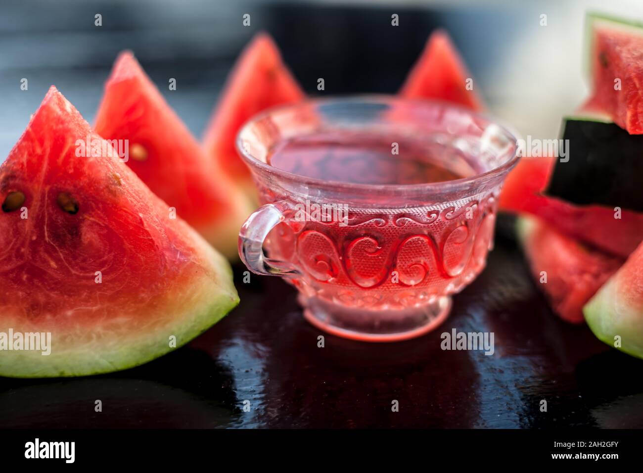 Fruit ice tea of watermelon seeds in a transparent glass cup on wooden ...
