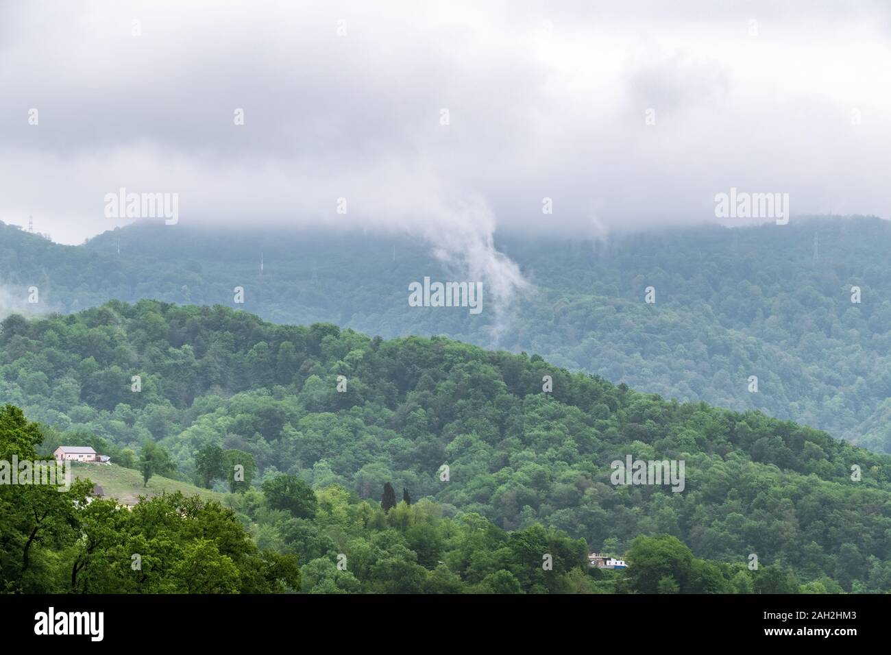 Layers of green mountains and hills in the haze during sunset ...