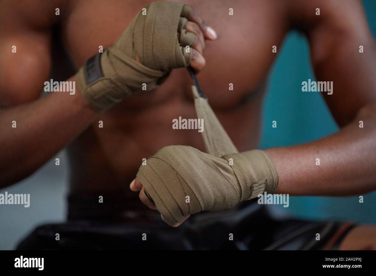 Close-up of African muscular boxer wearing bandage on his hands and ...