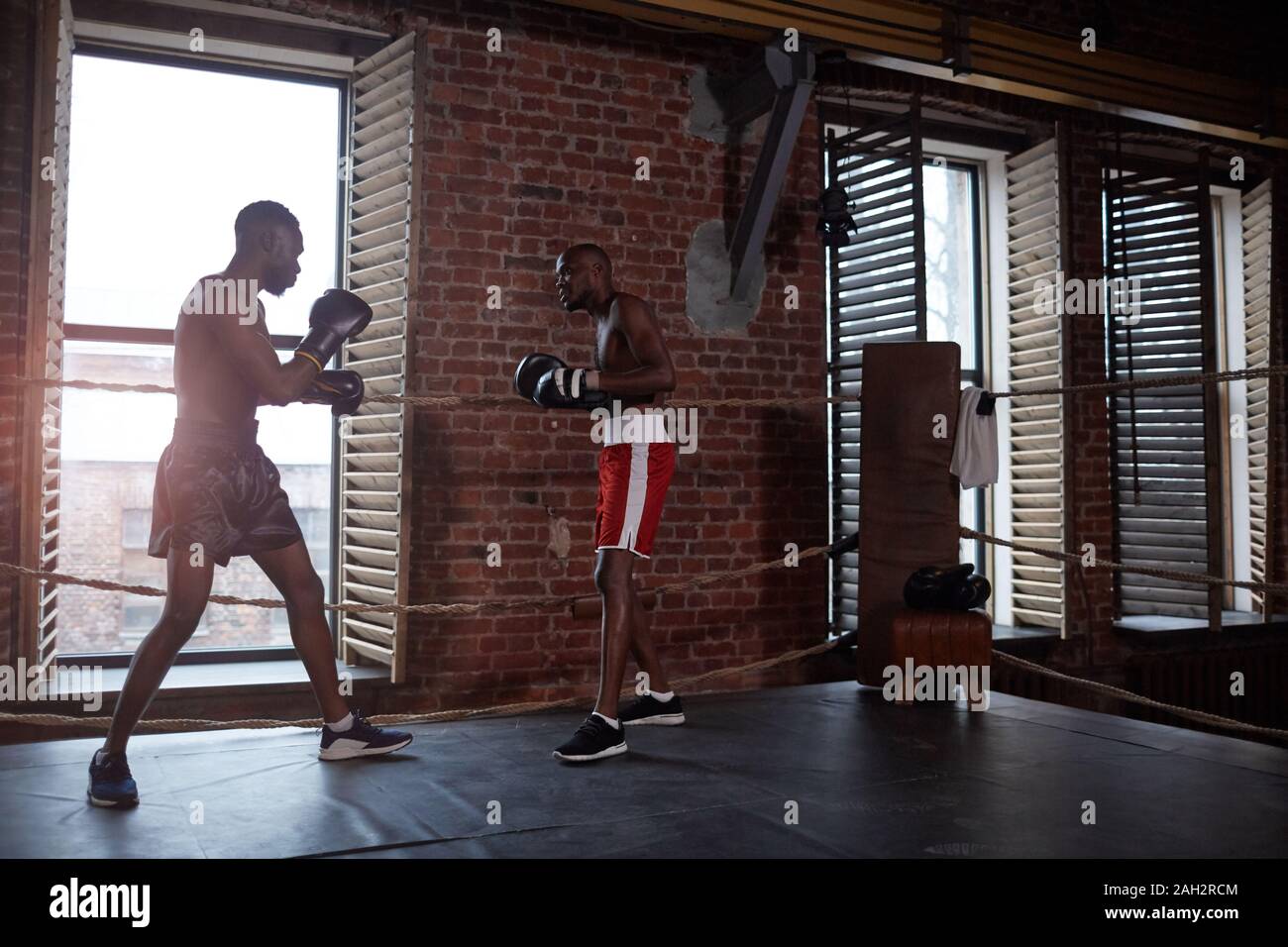 Two African boxers in sports clothing fighting with each other on ...