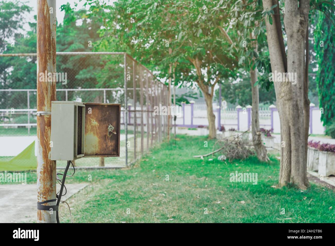 Old rusty electrical power control box on rusted electric pole in the ...