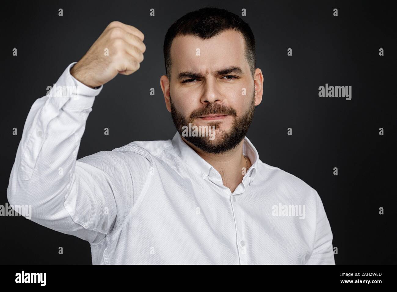 portrait of angry bearded man on black background. he threatens someone ...
