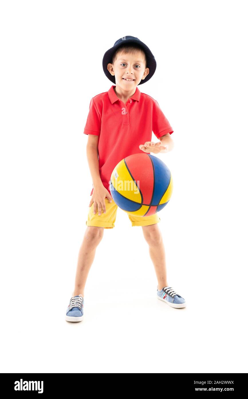 attractive young sporty smiling boy throws a basketball ball on a white ...