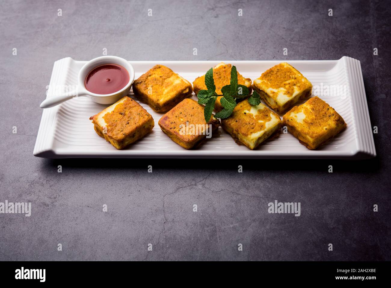 Amritsari Paneer Tikka made using cottage cheese cubes dipped in a ...