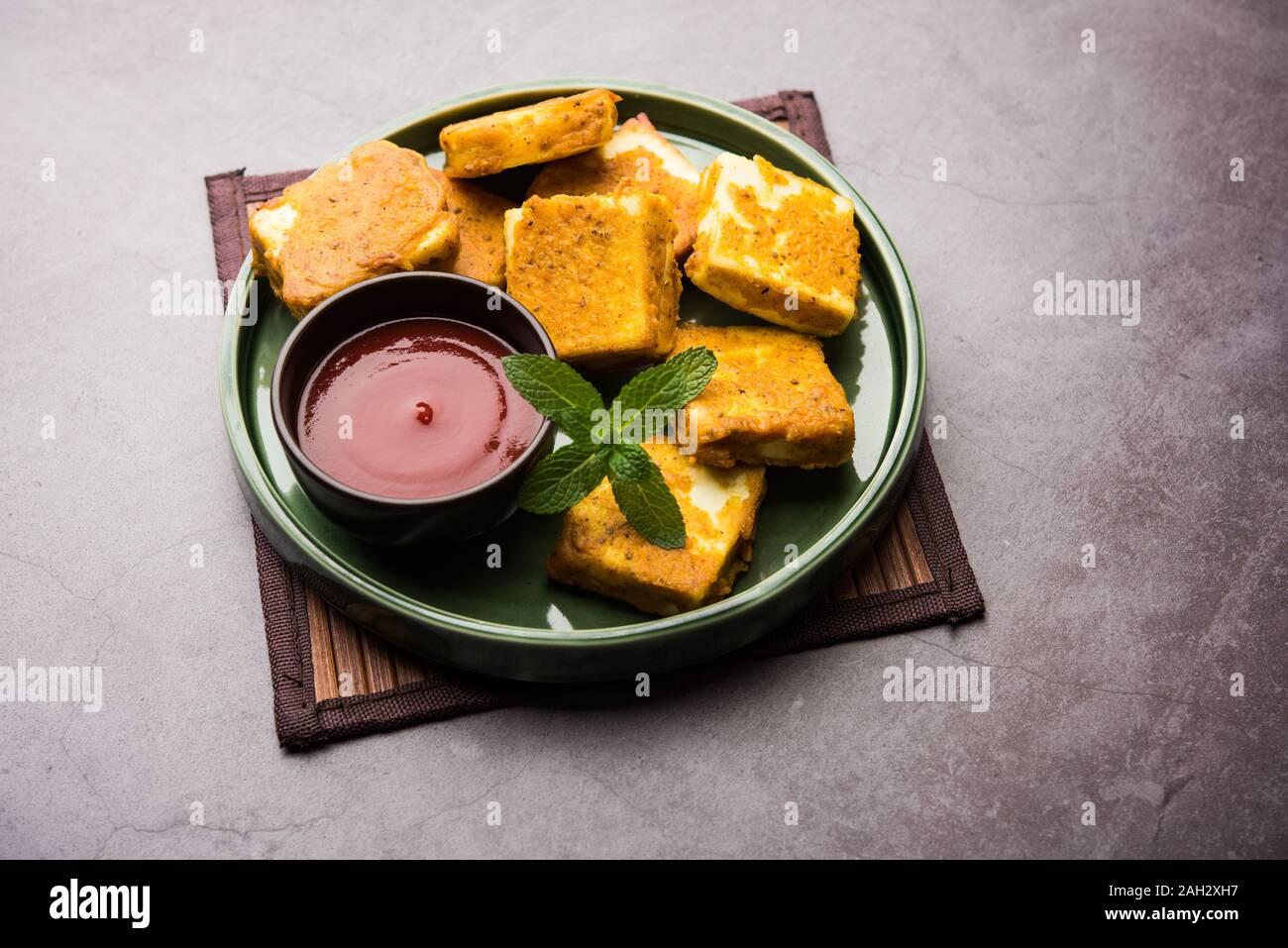 Amritsari Paneer Tikka made using cottage cheese cubes dipped in a ...