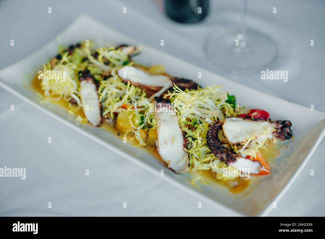 CHARRED octopus with vegetables and salad in restaurant Stock Photo - Alamy