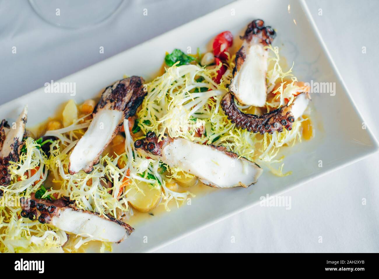 CHARRED octopus with vegetables and salad in restaurant Stock Photo - Alamy